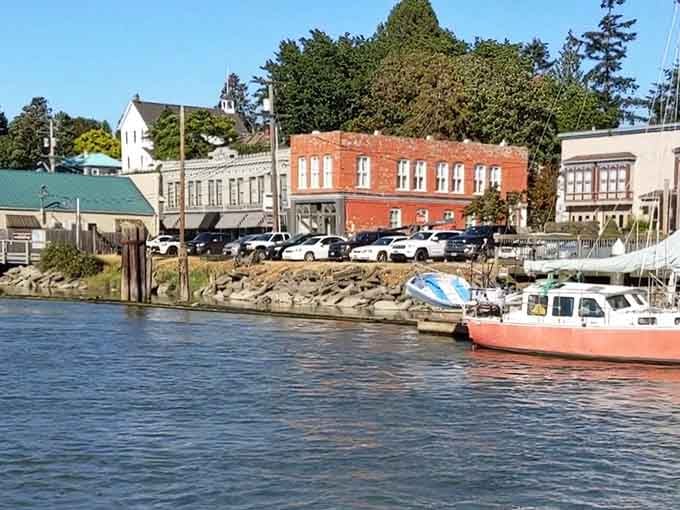Historic brick buildings face the water from their rocky perch, their windows reflecting over a century of maritime stories.