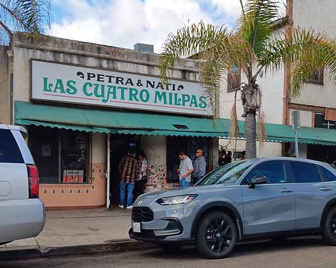 Palm trees frame this humble building where locals have been lining up for generations of delicious tradition.