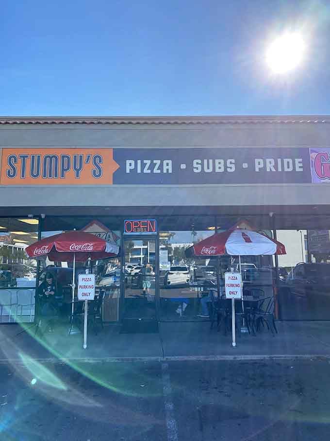 Stumpy's no-nonsense storefront tells you exactly what you're getting: Pizza, Subs, and Pride. The Coca-Cola umbrellas add a classic touch.