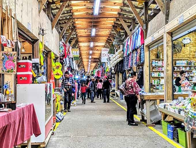 Rustic wooden beams frame a corridor of commerce where handmade meets vintage in perfect harmony under warm lighting.