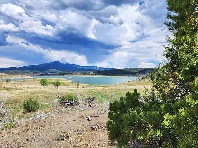 Storm clouds gather dramatically over the turquoise lake, creating that perfect moody landscape worthy of a postcard collection.