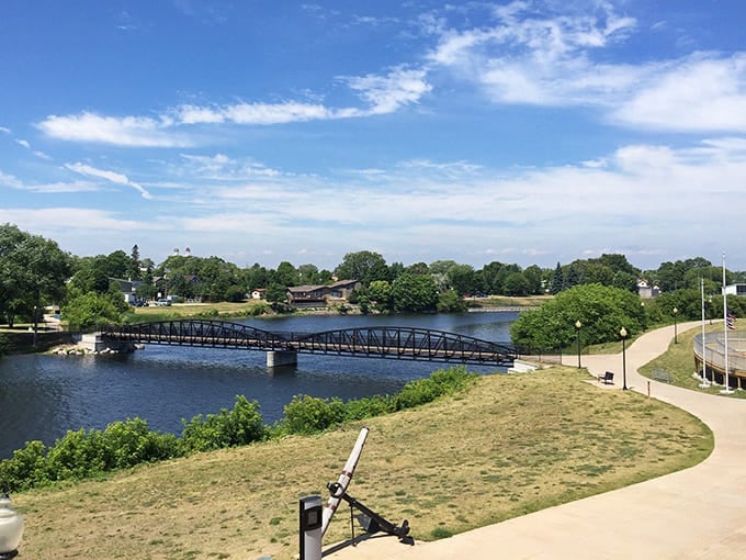 Green river waters flow beneath blue bridges, connecting communities and creating views that belong in travel magazines everywhere.