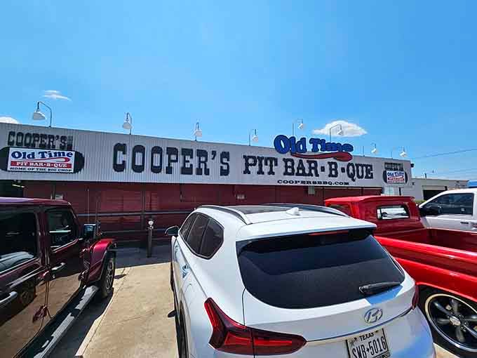 Where pickup trucks gather like faithful disciples around a temple of smoke, mesquite, and meat-based happiness.