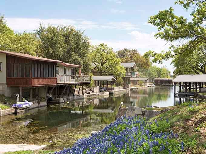 Waterfront homes nestle along peaceful shores where bluebonnets bloom, creating a postcard-perfect lakeside retreat every spring.
