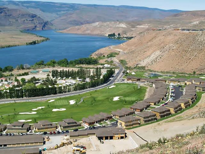 A golf course hugs the river while brown hills prove that even desert landscapes can support surprisingly green dreams.