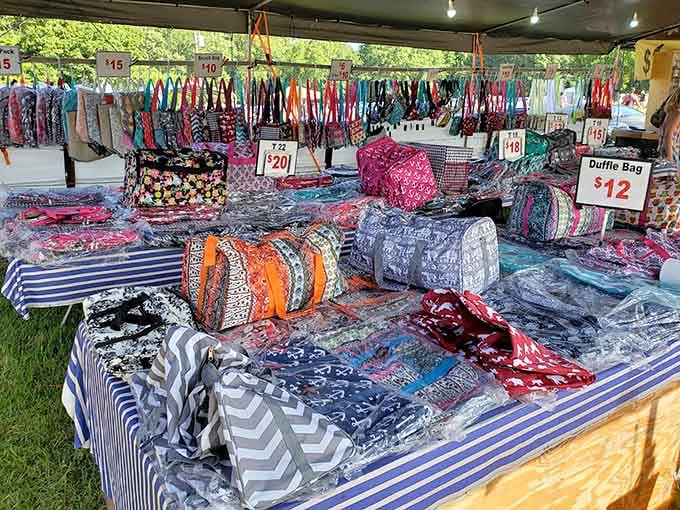 Colorful bags and purses hang like a rainbow exploded over this outdoor booth in the best way.