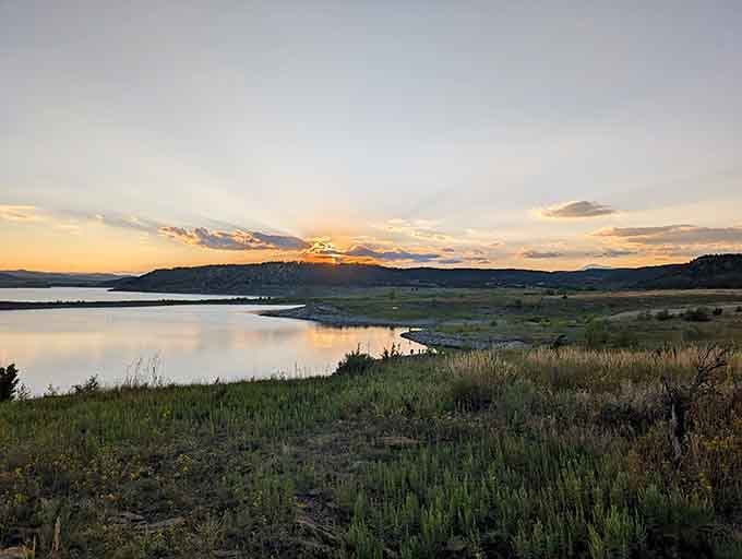 Sunset paints the water in soft pastels while grasslands glow golden—it's the kind of evening that restores your soul.