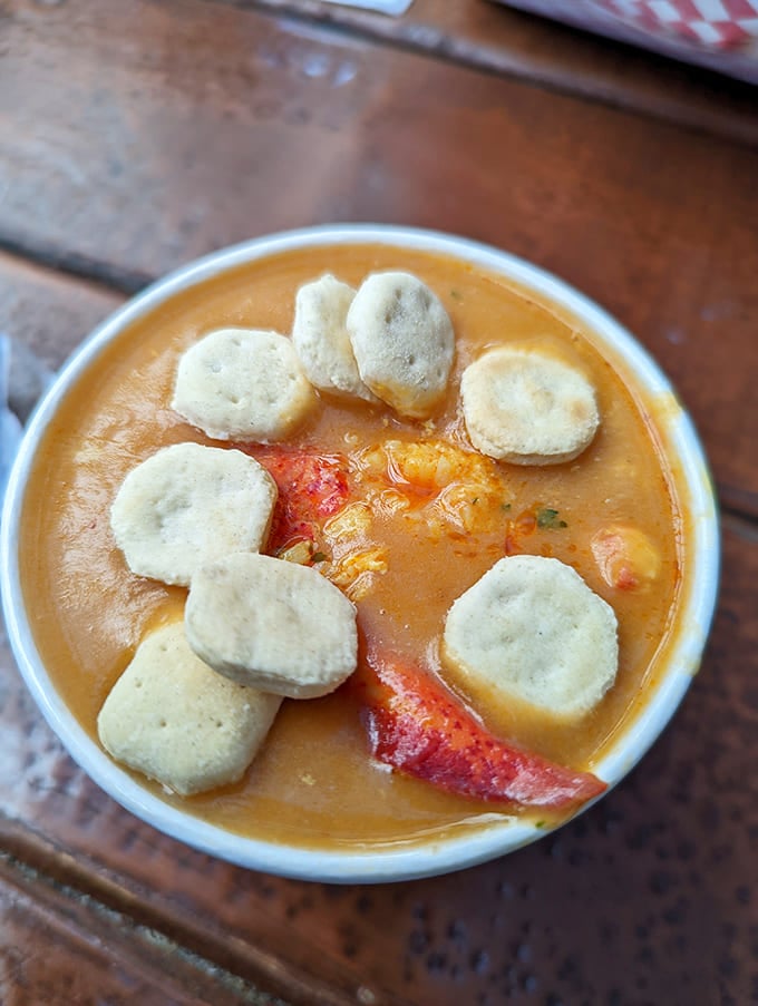 The lobster bisque wears its oyster crackers like a crown, the rich broth hiding treasures of the sea beneath its surface.