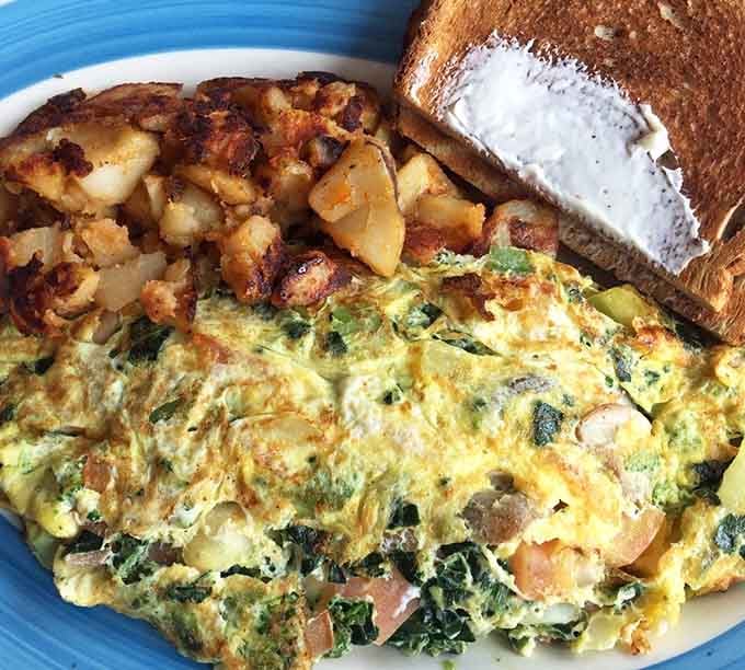 That omelet is stuffed fuller than a Thanksgiving turkey, with home fries that deserve their own standing ovation.