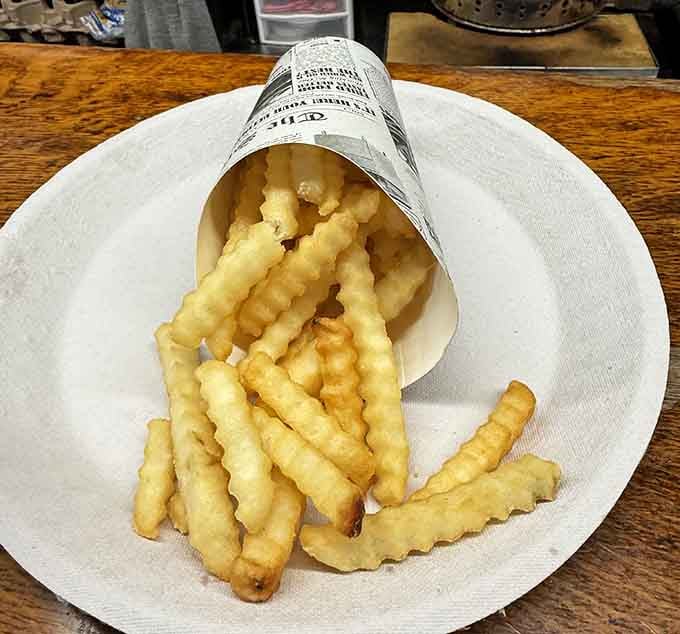 Crinkle-cut fries served in paper because sometimes the old ways are the best ways, no apologies needed or given.