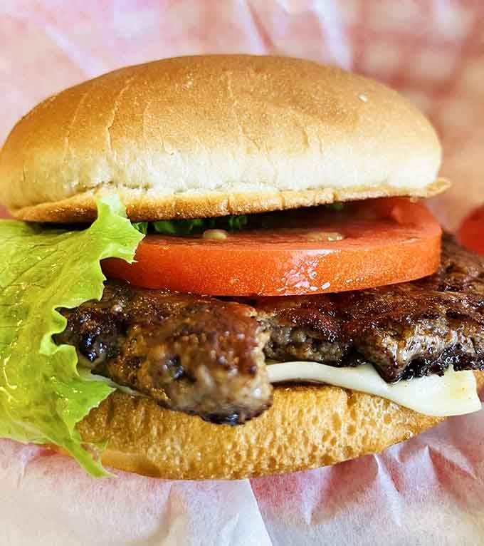 Behold the burger in its natural habitat&mdash;perfectly charred patty, melty cheese, fresh veggies, and a bun that knows its supporting role without stealing the show.