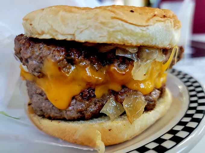 Two patties, melted cheese, and grilled onions form a tower of deliciousness that demands your full attention.