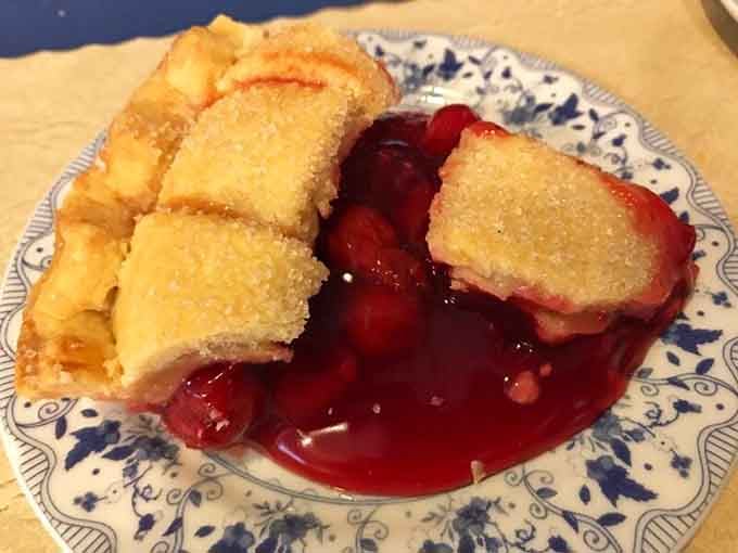 Cherry pie so vibrant it looks like it's blushing at all the attention, with a sugar-dusted crust that crackles with each forkful.