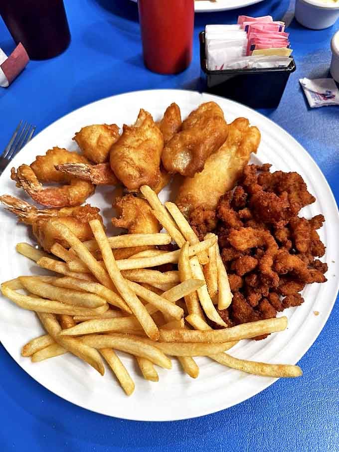 The holy trinity of fried goodness&mdash;fish, shrimp, and fries sharing a plate like old friends at a delicious reunion party.
