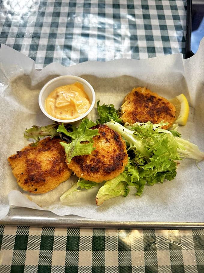 These golden crab cakes perched atop fresh greens aren't just appetizers&mdash;they're edible postcards from the pristine waters of Prince William Sound.