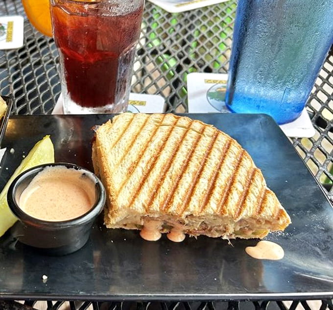 A Cuban sandwich grilled to golden perfection, served with sauce that probably has its own fan club by now.