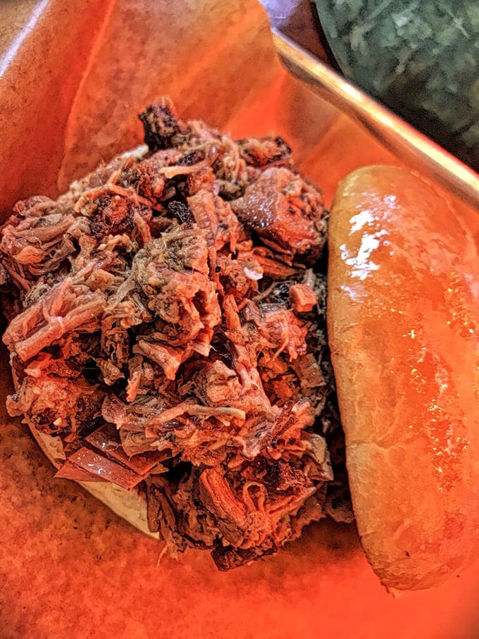 Beef piled high on a tray with sauce that glows like liquid gold in the light.