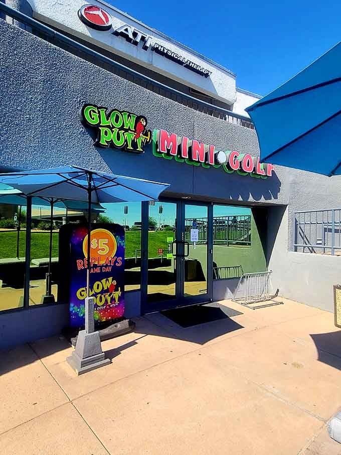 The unassuming exterior hides a neon wonderland inside, like Clark Kent's phone booth but for mini golf enthusiasts.