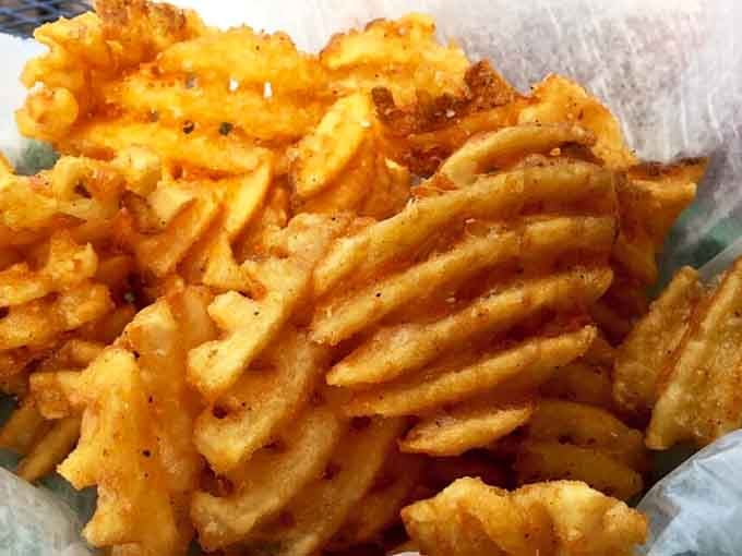 Waffle fries with that perfect golden-brown color and crinkly texture that makes regular fries look like they're not even trying anymore.