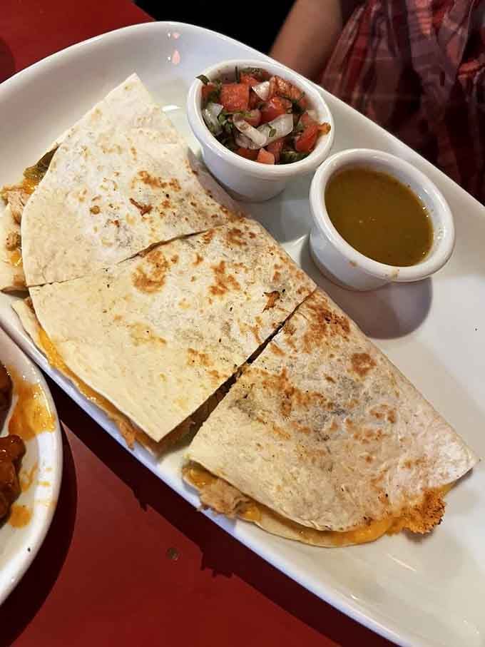 Golden quesadillas arrive with fresh pico and salsa verde, because even comfort food joints understand balance.