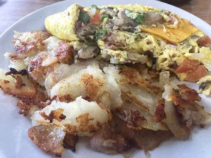 This isn't just breakfast &ndash; it's edible art. The omelet's vibrant fillings play perfectly against those gloriously crispy home fries. Morning perfection achieved!