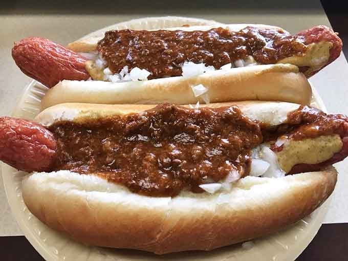 That generous blanket of chili and onions transforms a simple hot dog into a full-blown flavor experience.