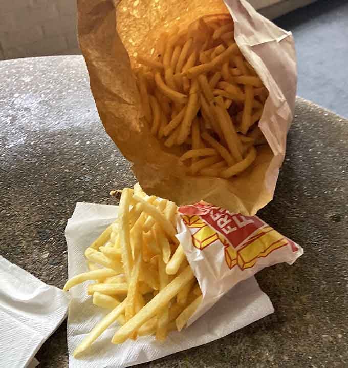 Golden fries spilling out like treasure, because sometimes the side dish deserves equal billing with the main attraction.