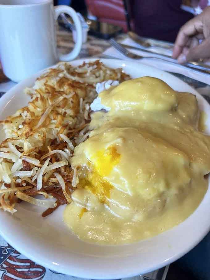 Eggs Benedict smothered in hollandaise with crispy hash browns, because some mornings demand the full treatment without apology.