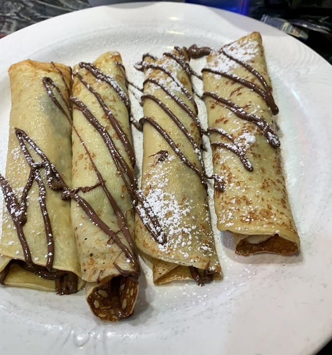 Nutella and banana wrapped in delicate crepes, drizzled with chocolate, dusted with powdered sugar equals pure breakfast poetry.