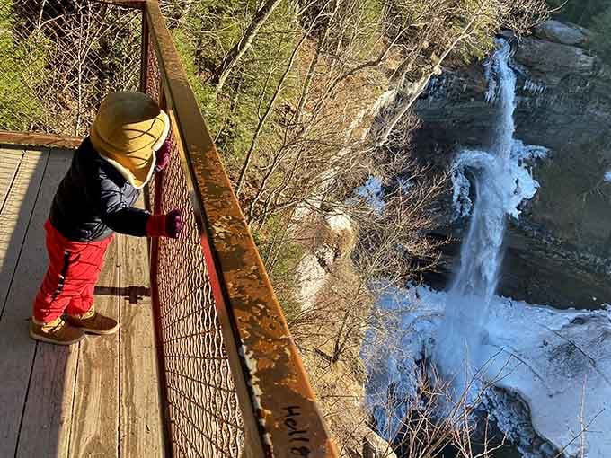 Standing at the rocky pool's edge, you're close enough to feel the waterfall's refreshing mist on your face.