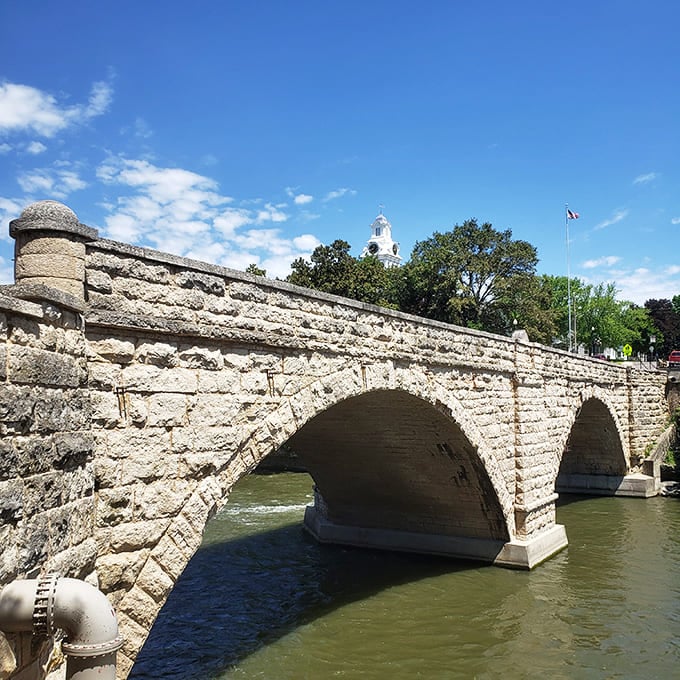 The 1889 Keystone Bridge arches gracefully over the Turkey River, a limestone masterpiece that's been photobombing family vacation pictures for over a century.