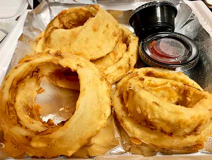 Onion rings so substantial they could double as Olympic gymnastic equipment, served with dipping sauce for maximum enjoyment.