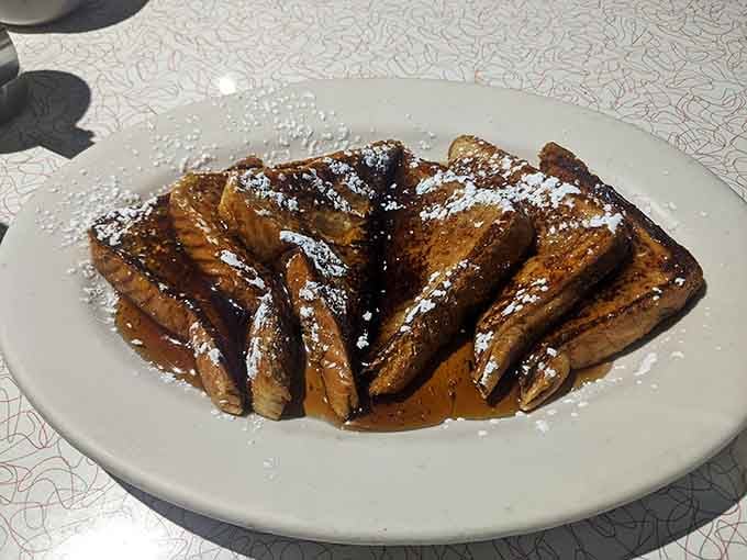 French toast dusted with powdered sugar and drizzled with syrup, because sometimes simple pleasures are the best pleasures.