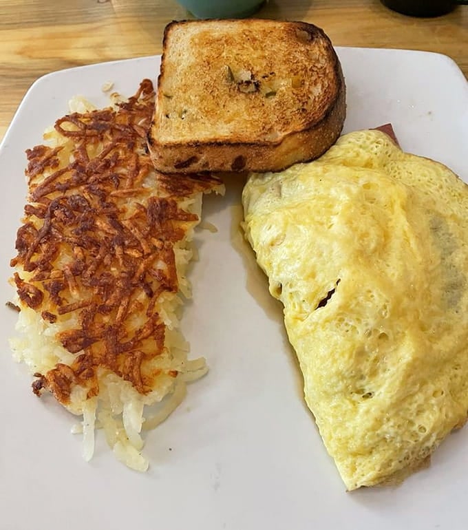 Golden hash browns meet a fluffy omelet on a plate that understands the assignment and deserves an A-plus for effort.