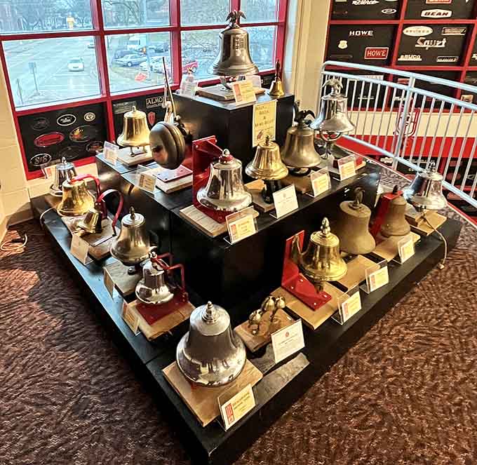 A collection of brass bells that once announced emergencies now sits in polished, peaceful retirement.