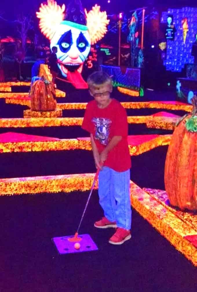 Future mini golf champion in training, proving that spooky and spectacular make the perfect combination for family fun.