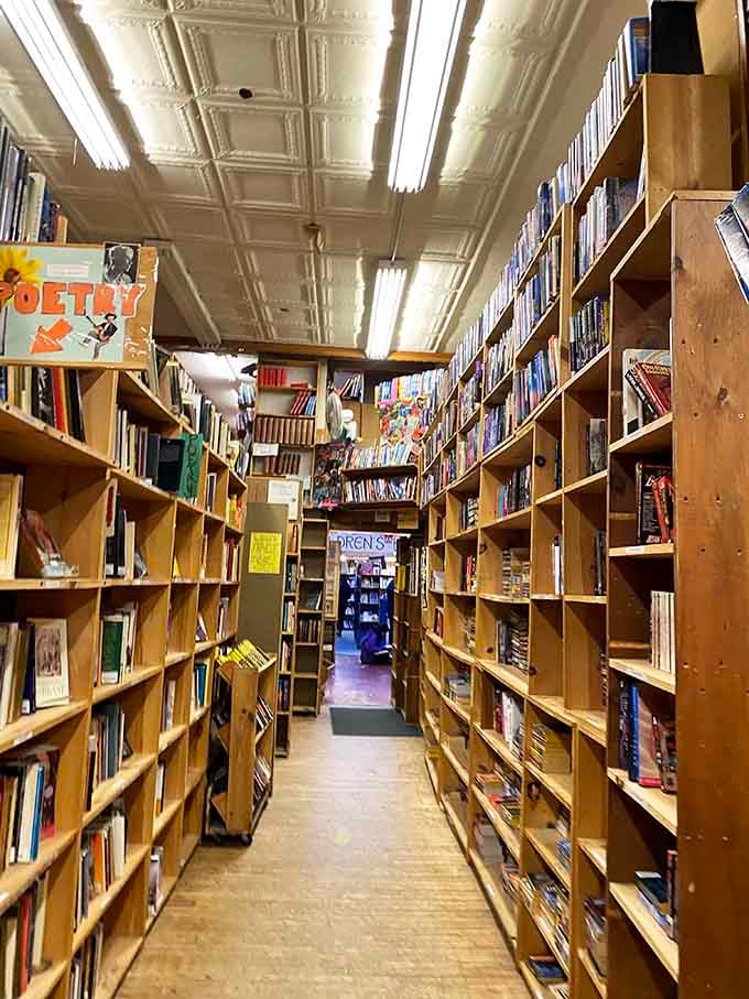 The tin ceiling and endless wooden shelves create that classic bookstore atmosphere that makes Amazon feel suddenly very cold and sterile.