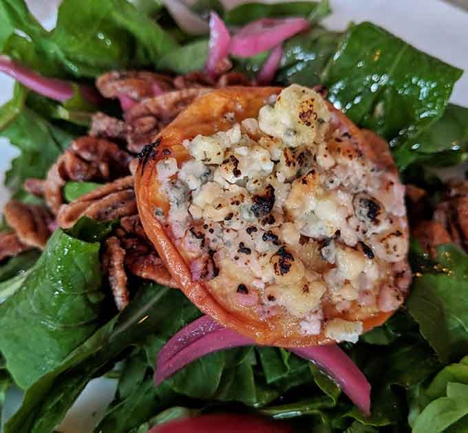 A blue cheese stuffed peach perched atop fresh greens transforms salad from obligation into celebration worth photographing.