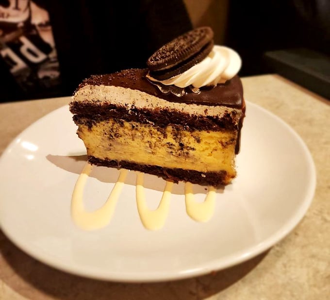 This towering Oreo cheesecake slice is what happens when someone decides more is definitely more, and they're absolutely right.
