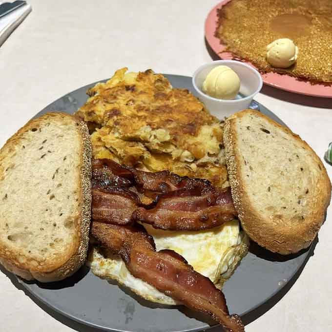 A breakfast plate so perfectly composed it deserves its own gallery showing, complete with crispy bacon and golden toast.