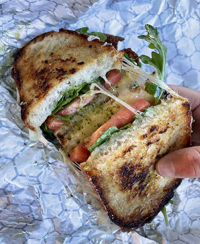 That golden-grilled perfection holds fresh ingredients that make you question every sad desk lunch you've ever eaten.
