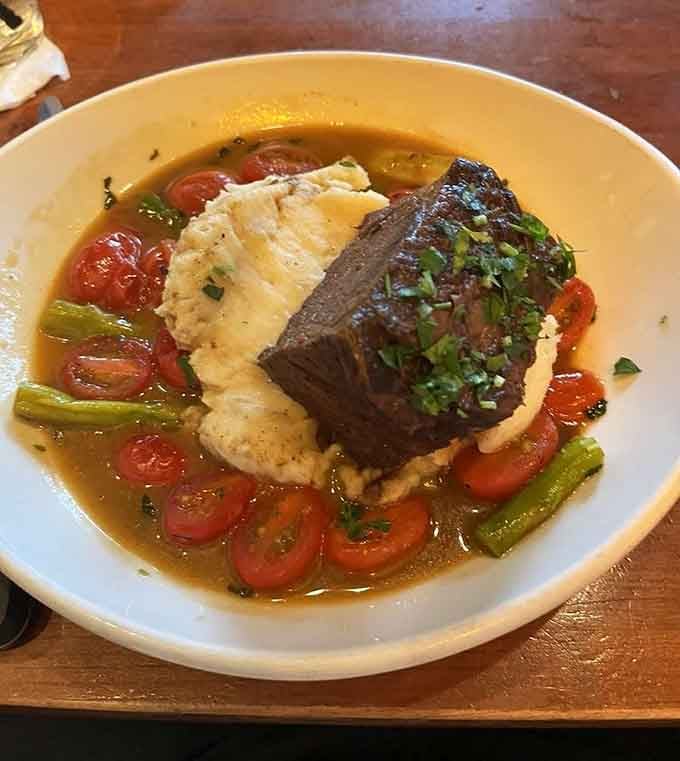 Tender braised short rib nestled in creamy polished with roasted tomatoes looks like pure comfort on a plate.