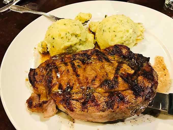 This ribeye doesn't just sit on the plate&mdash;it commands attention with perfect grill marks and a side of mashed potatoes that could make a carb-counter weep.