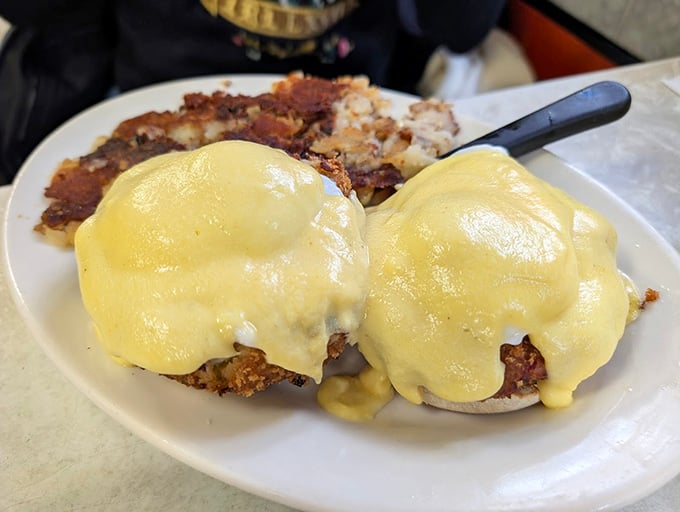 Eggs Benedict with hollandaise that flows like liquid gold over perfectly poached eggs and crispy hash browns.