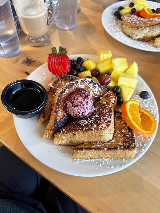 French toast arrives like edible sunshine, dusted with powdered sugar and ready to make your morning absolutely spectacular.