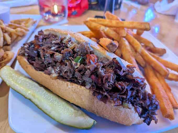 Philly cheesesteak hiding behind a name that sounds like a hunting accident, complete with fries and a pickle spear.