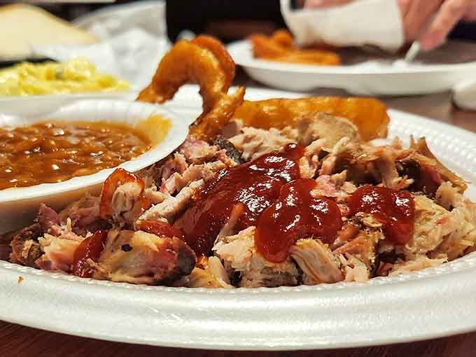 Tender pulled pork glistening with sauce proves why this barbecue joint earned its legendary reputation across Alabama.