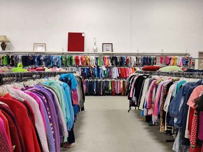 Rows of clothing create a fabric canyon, color-coded paths leading to your next wardrobe revelation.