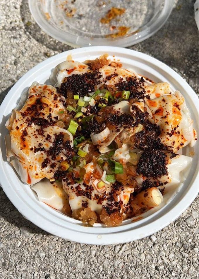 Wontons bathed in chili oil and topped with scallions, proving that beauty comes in spicy packages.
