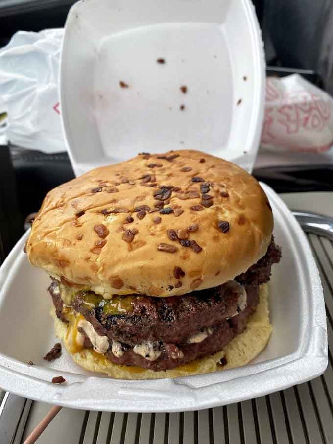 Not your average drive-thru burger. This hefty creation demands both hands, a stack of napkins, and a moment of silent appreciation.